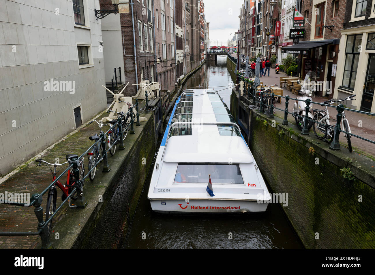 A pleasure boat travelling on the canal in Amsterdsm, Holland ...