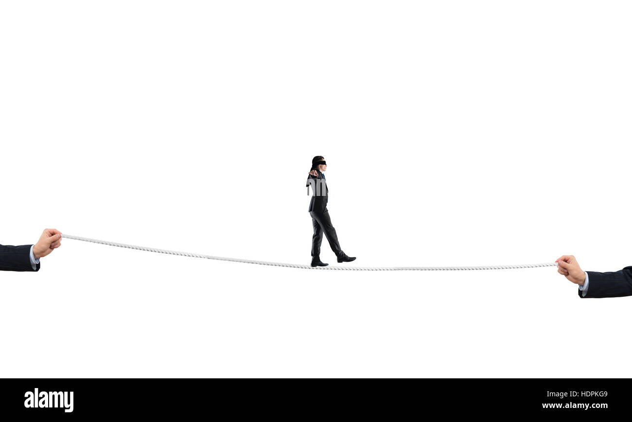 Young businessman in blindfold against white background walking on rope ...