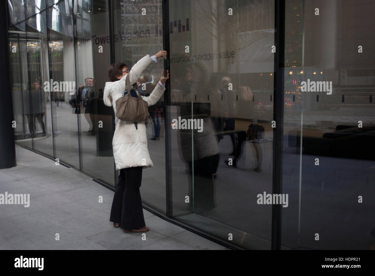 A woman uses her smartphone to photograph a corporate foyer interior ...