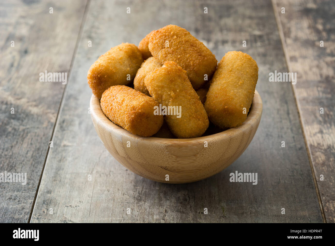 Traditional fried Spanish croquetas (croquettes) in bowl on wooden ...