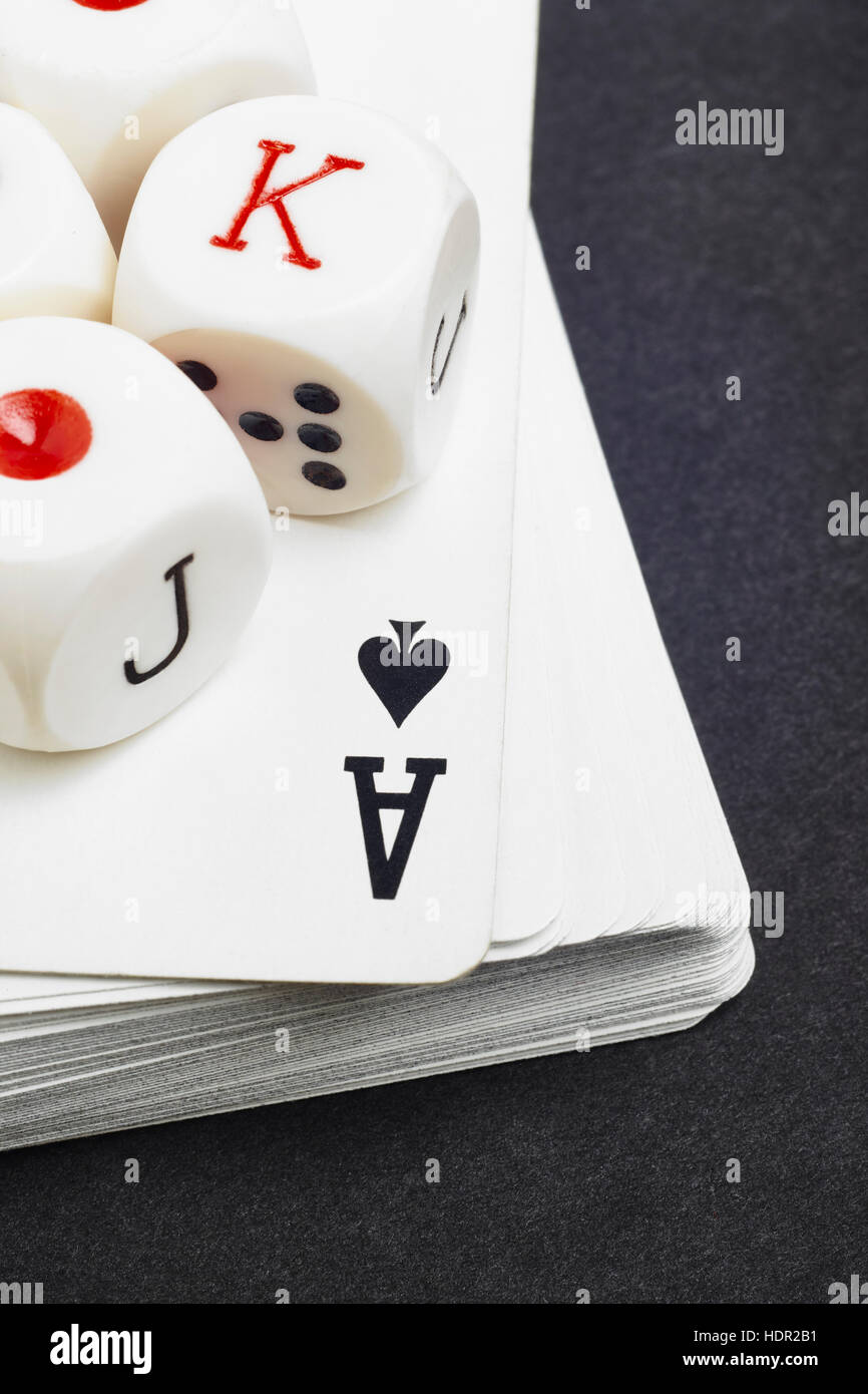 Dice and cards poker game over a black background. Vertical Stock Photo ...