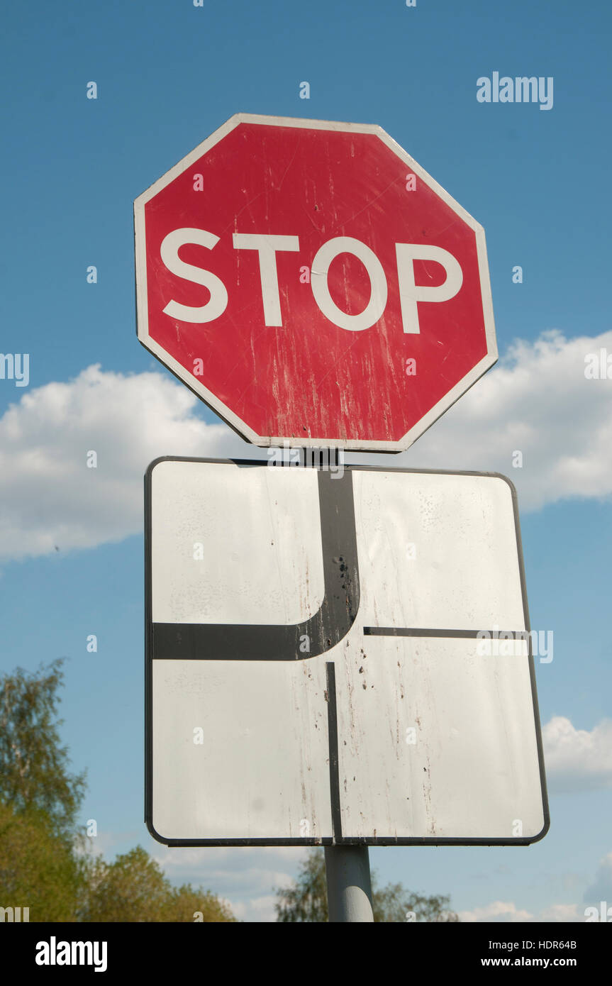 Road signs "Stop" and "Crossing with the main road Stock Photo - Alamy