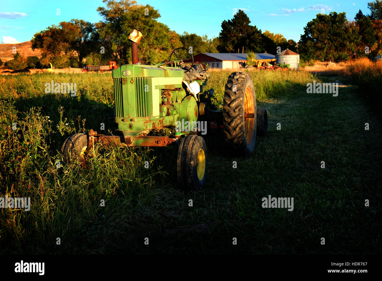 Old Tractor In Field on farm summer day Stock Photo - Alamy