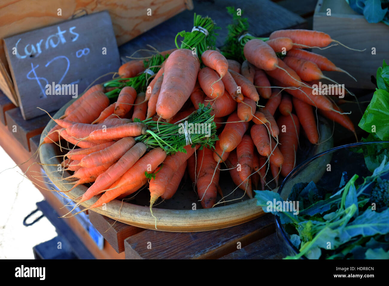 Fresh bunch of carrots grown and sold at farmer's market with sign for ...