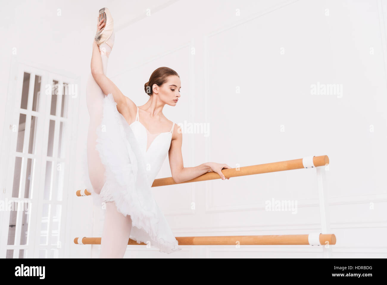 Elegant classical dancer touching her foot in the air Stock Photo - Alamy