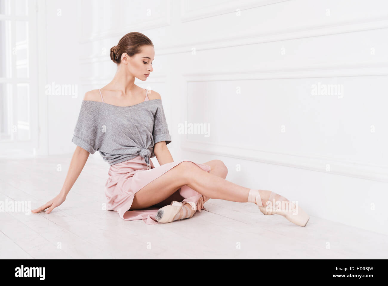 Serious young ballerina sitting on the floor Stock Photo - Alamy