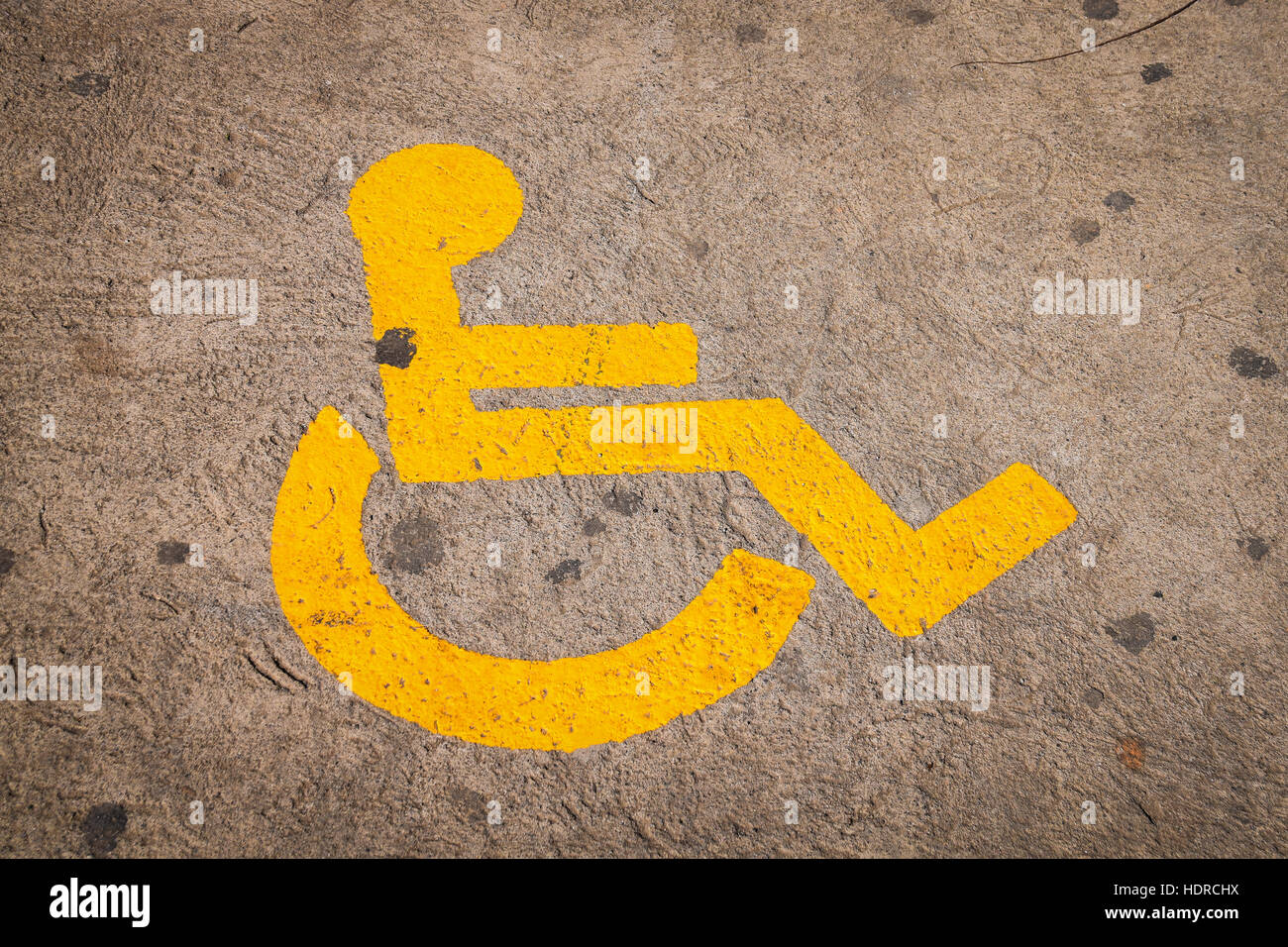 Yellow disabled sign on pathway near lowered kerb Stock Photo - Alamy