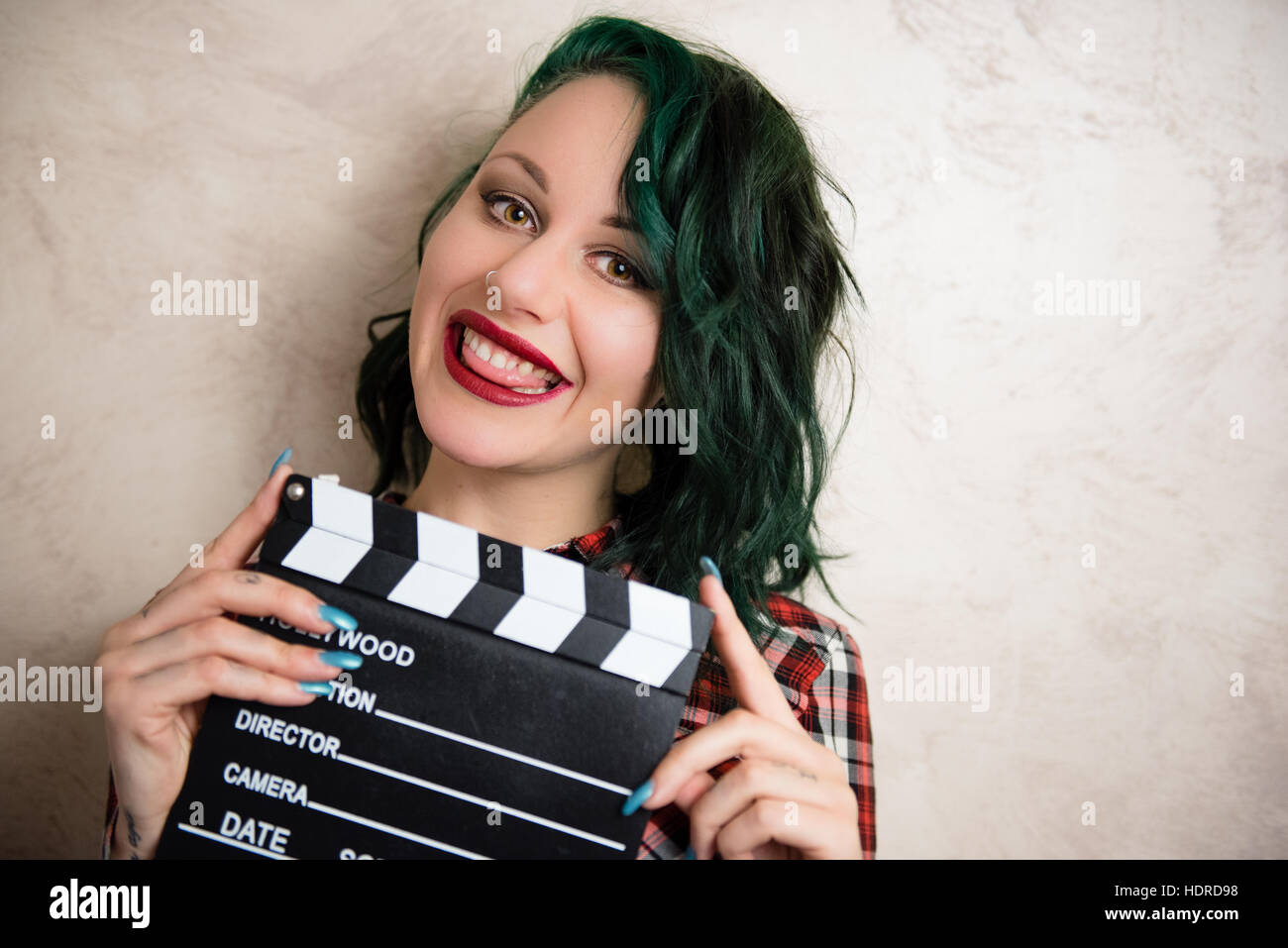 Young alternative girl smiling face posing with movie clapper board for ...