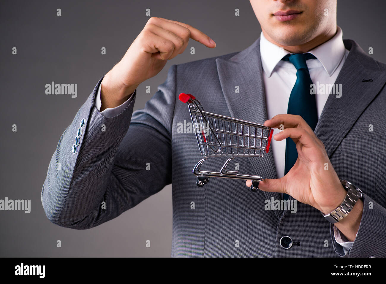 Businessman holding shopping cart in business concept Stock Photo - Alamy