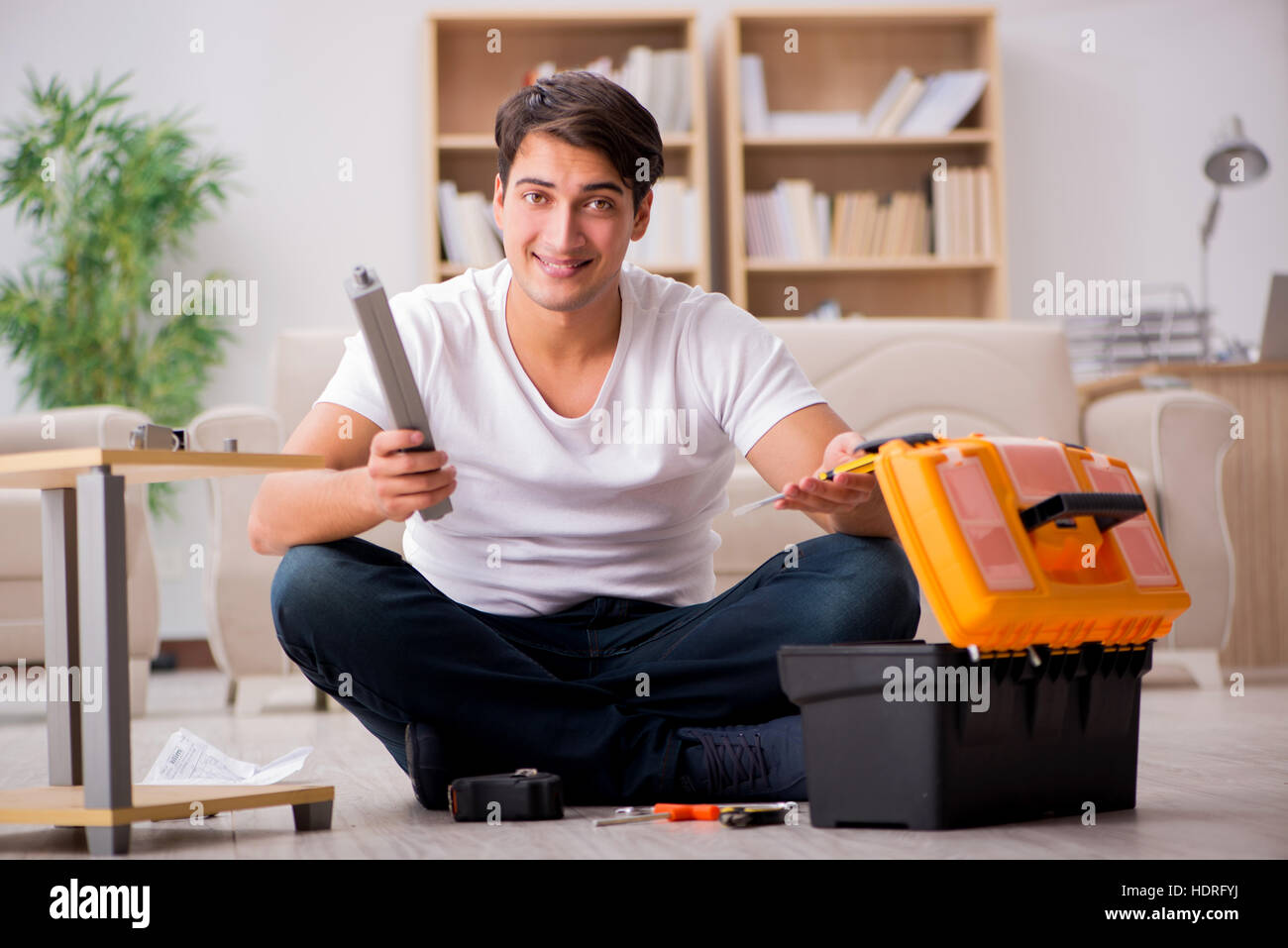 Man assembling shelf at home Stock Photo - Alamy