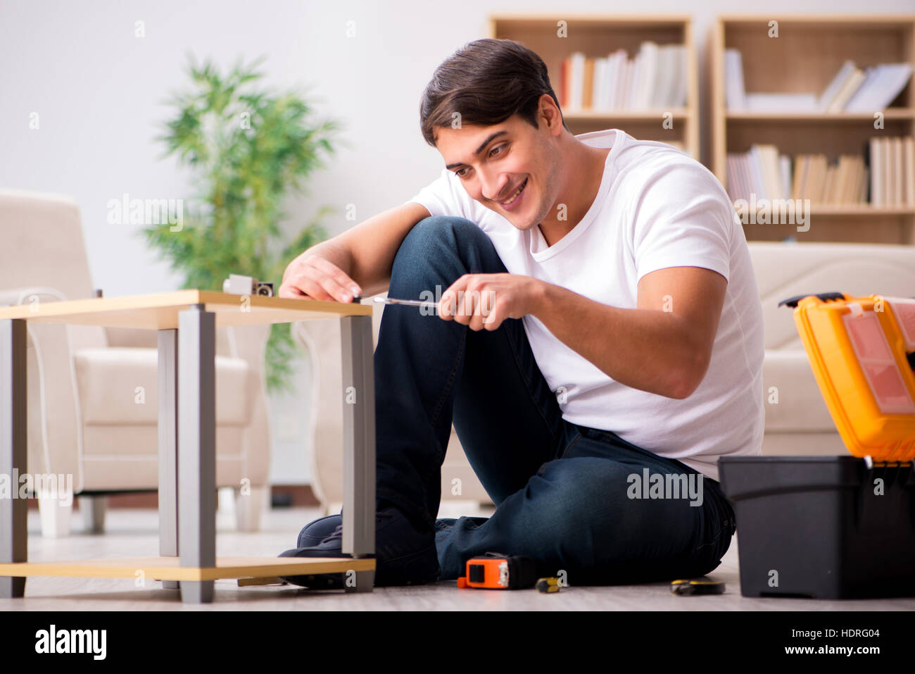 Man assembling shelf at home Stock Photo - Alamy