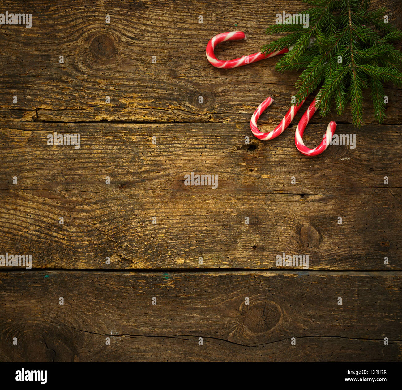 Christmas tree branches with candy canes on wooden texture ready for ...