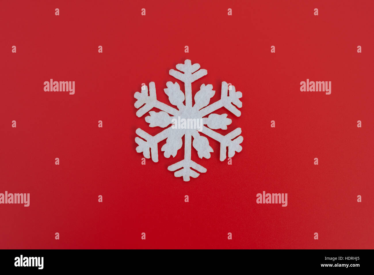 piece of white snowflake on a red background Stock Photo - Alamy