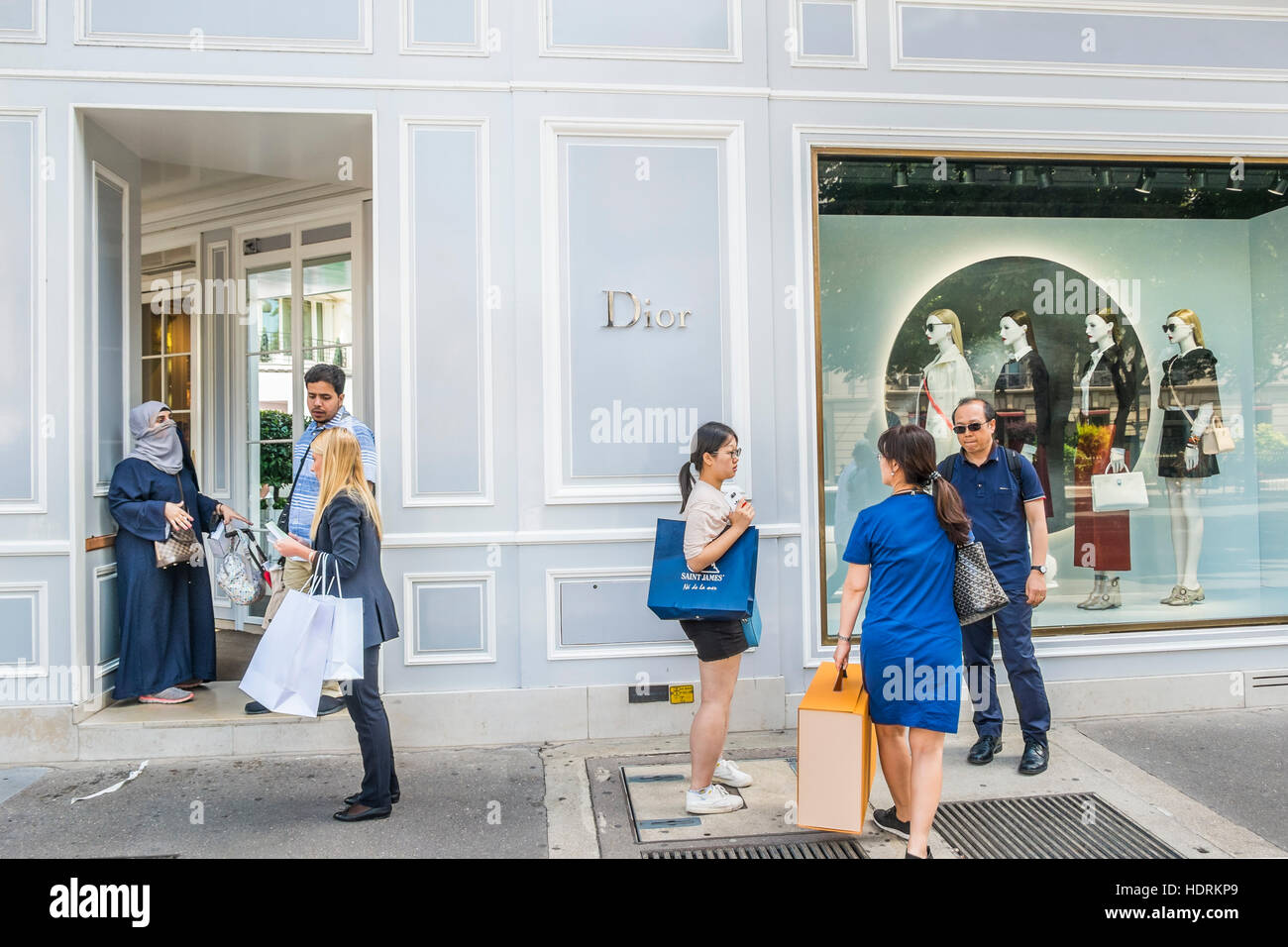 street scene in front of dior store, asian and arab fashion shoppers ...