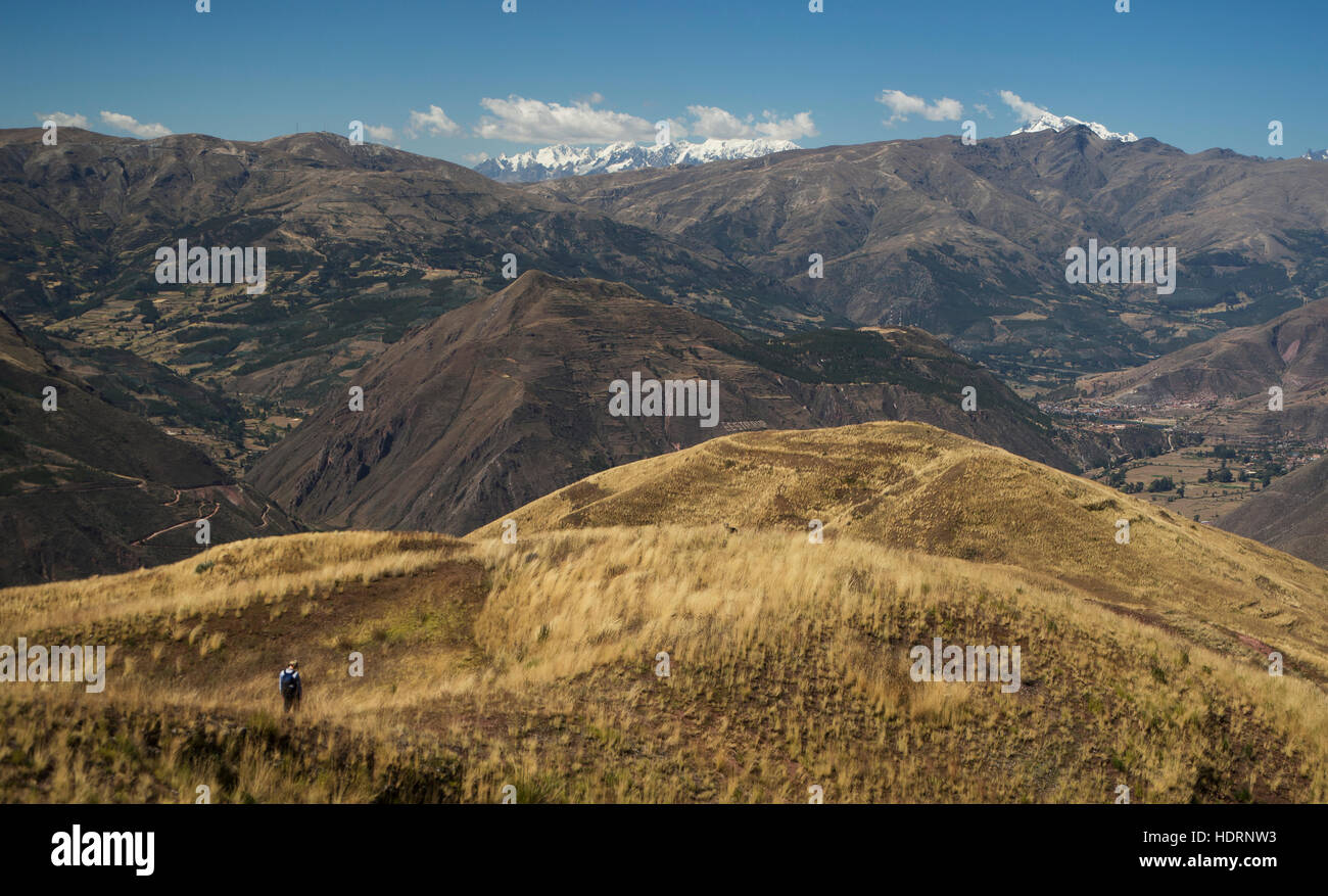A hiker makes his way through the foothills of the Andes Mountains with ...