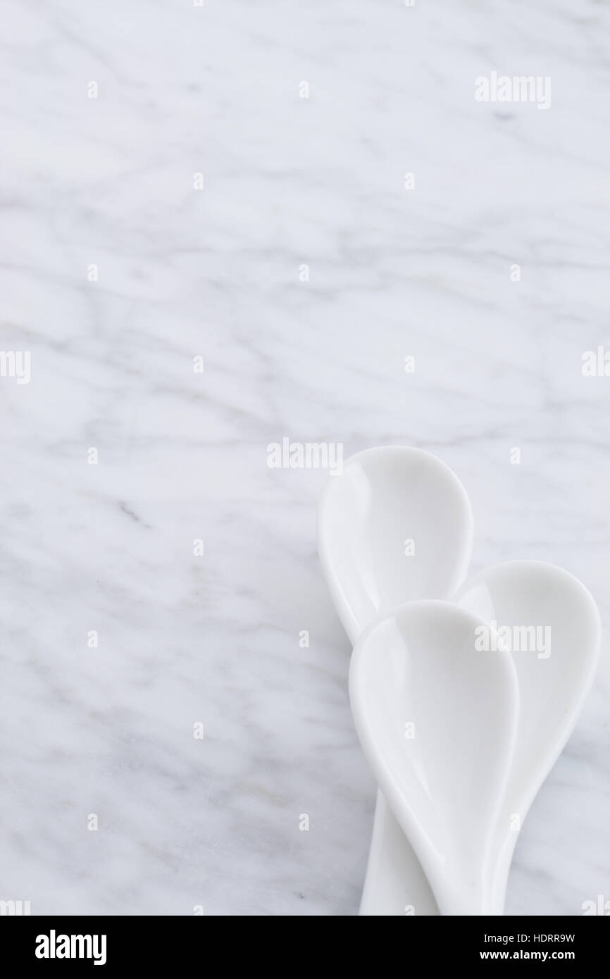 white spoon set styled on antique carrara marble Stock Photo - Alamy