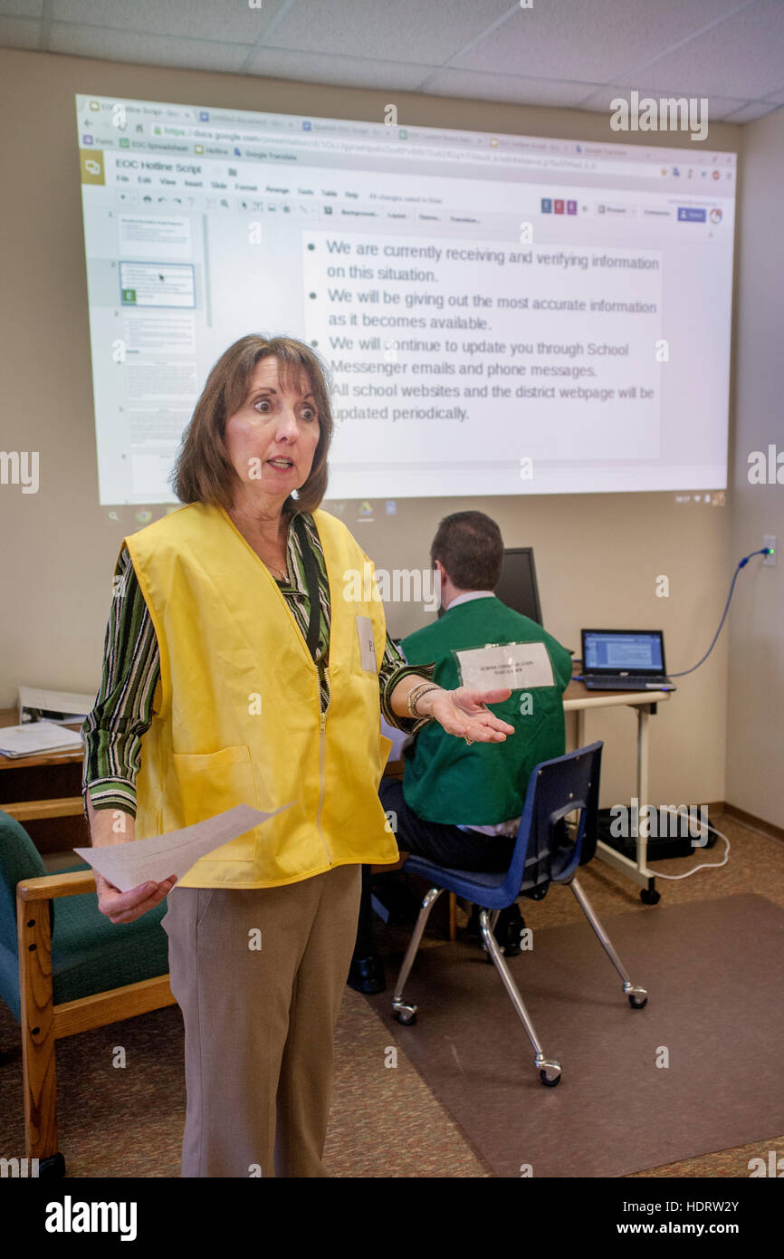 A school district administrator addresses volunteer teachers as they ...