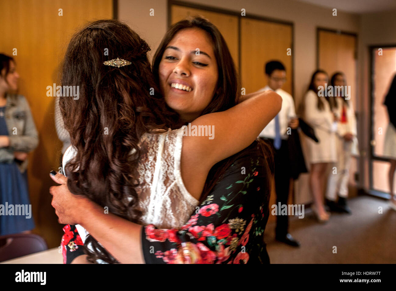 Hispanic teenage girls hug as they wait for Confirmation mass at a ...