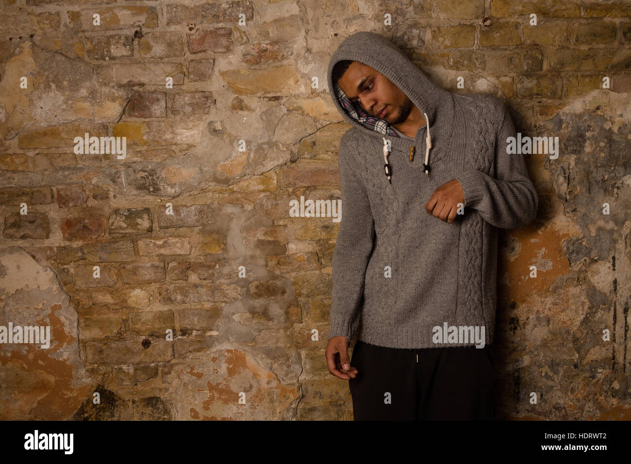 Drug addict posing near brick wall Stock Photo - Alamy