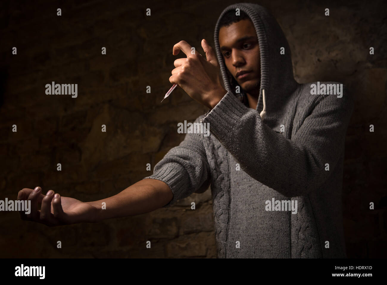 Drug addict posing near brick wall Stock Photo - Alamy