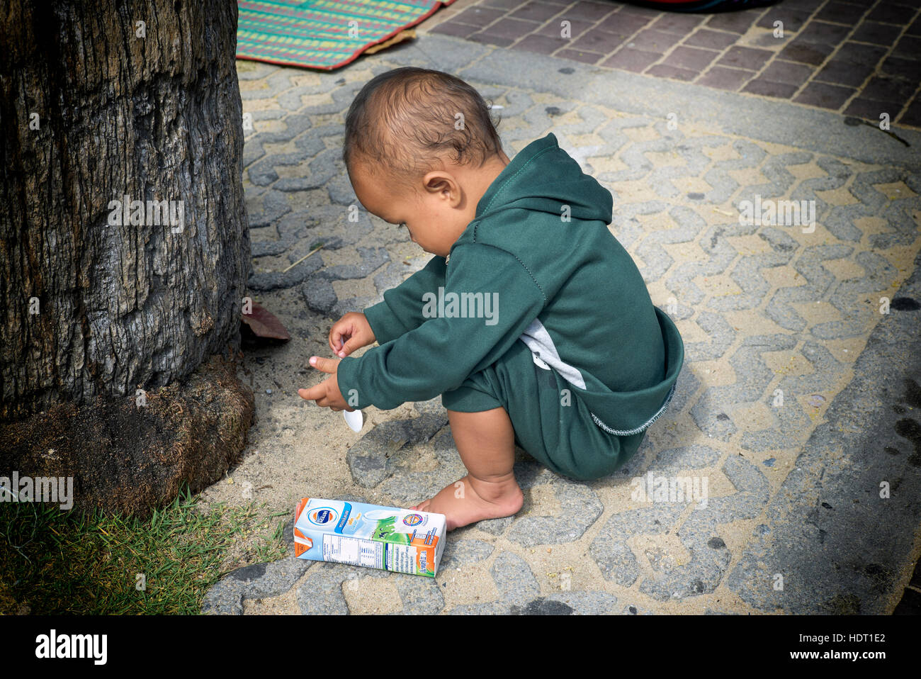 Child playing alone outside in the street. Thailand S. E. Asia Stock ...