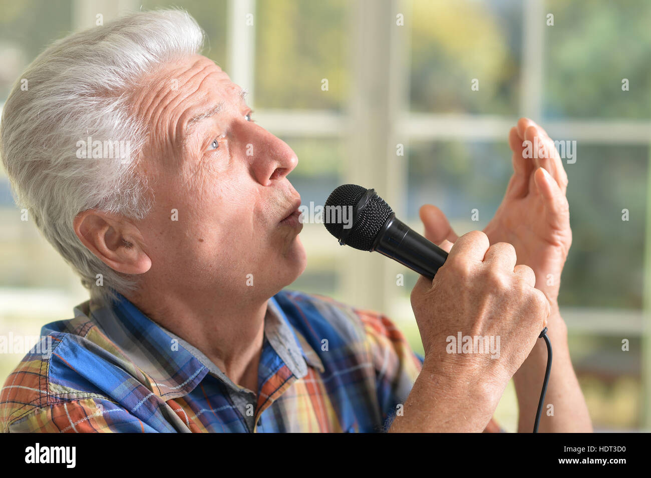 Senior man with microphone Stock Photo - Alamy
