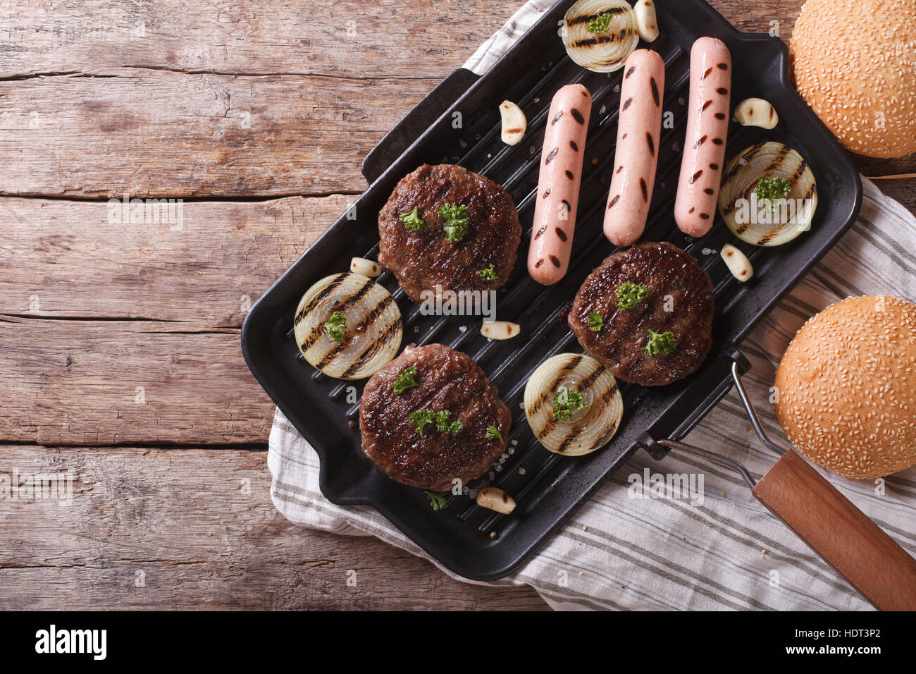 Burgers and sausages on a grill pan. horizontal view from above Stock ...