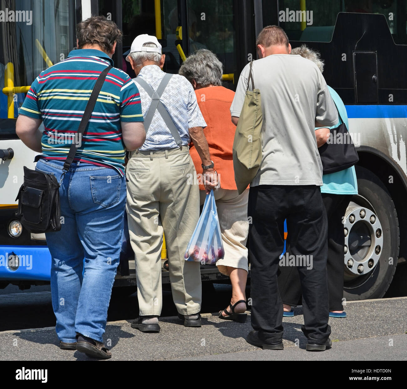People getting in to the bus at the bus stop Stock Photo - Alamy