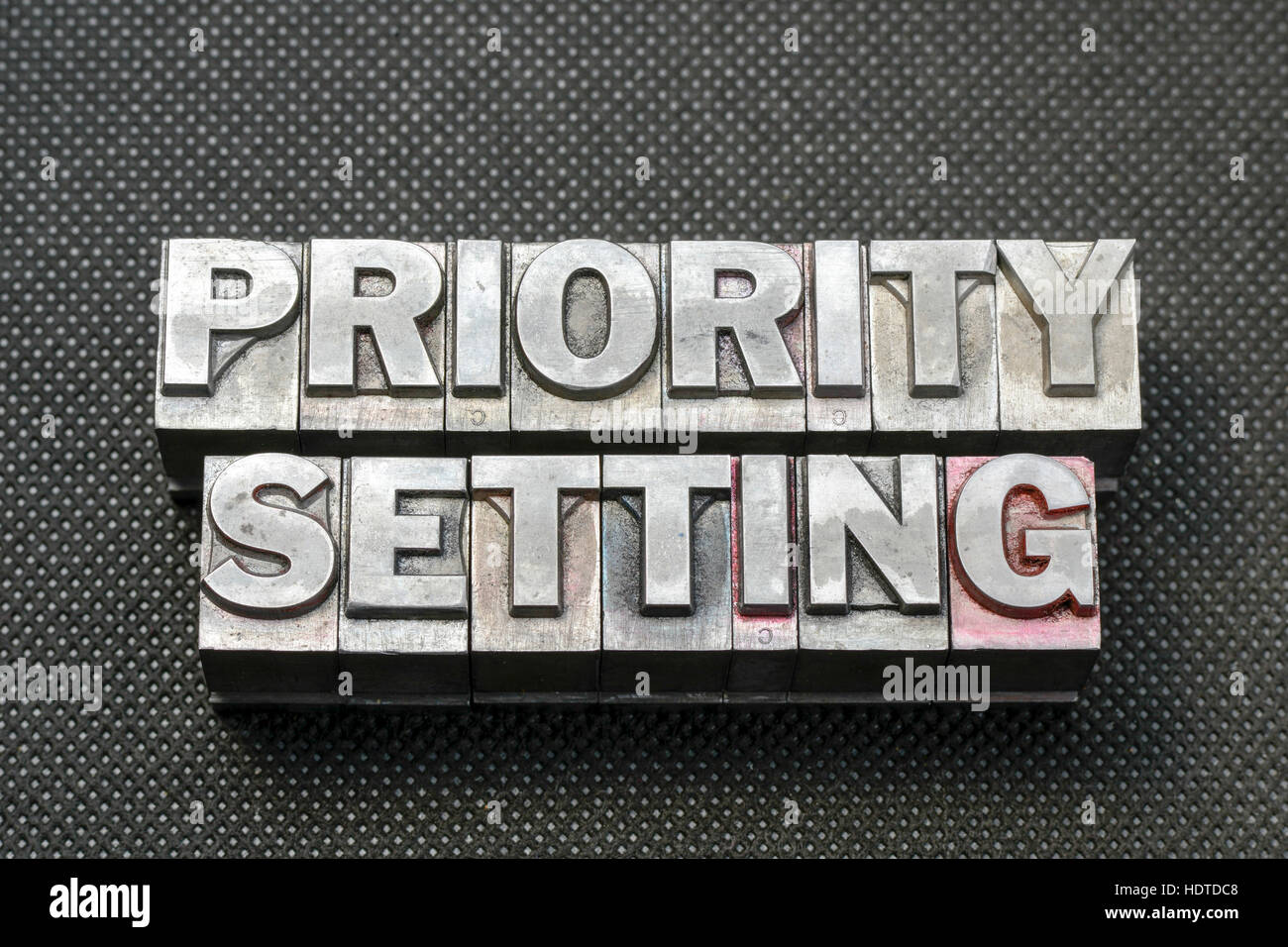 priority setting phrase made from metallic letterpress blocks on black ...