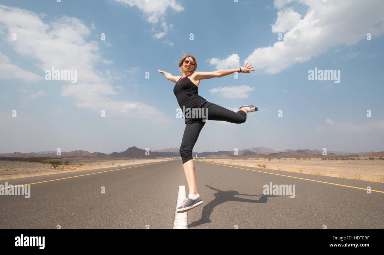 Young woman jumping on a road Stock Photo - Alamy