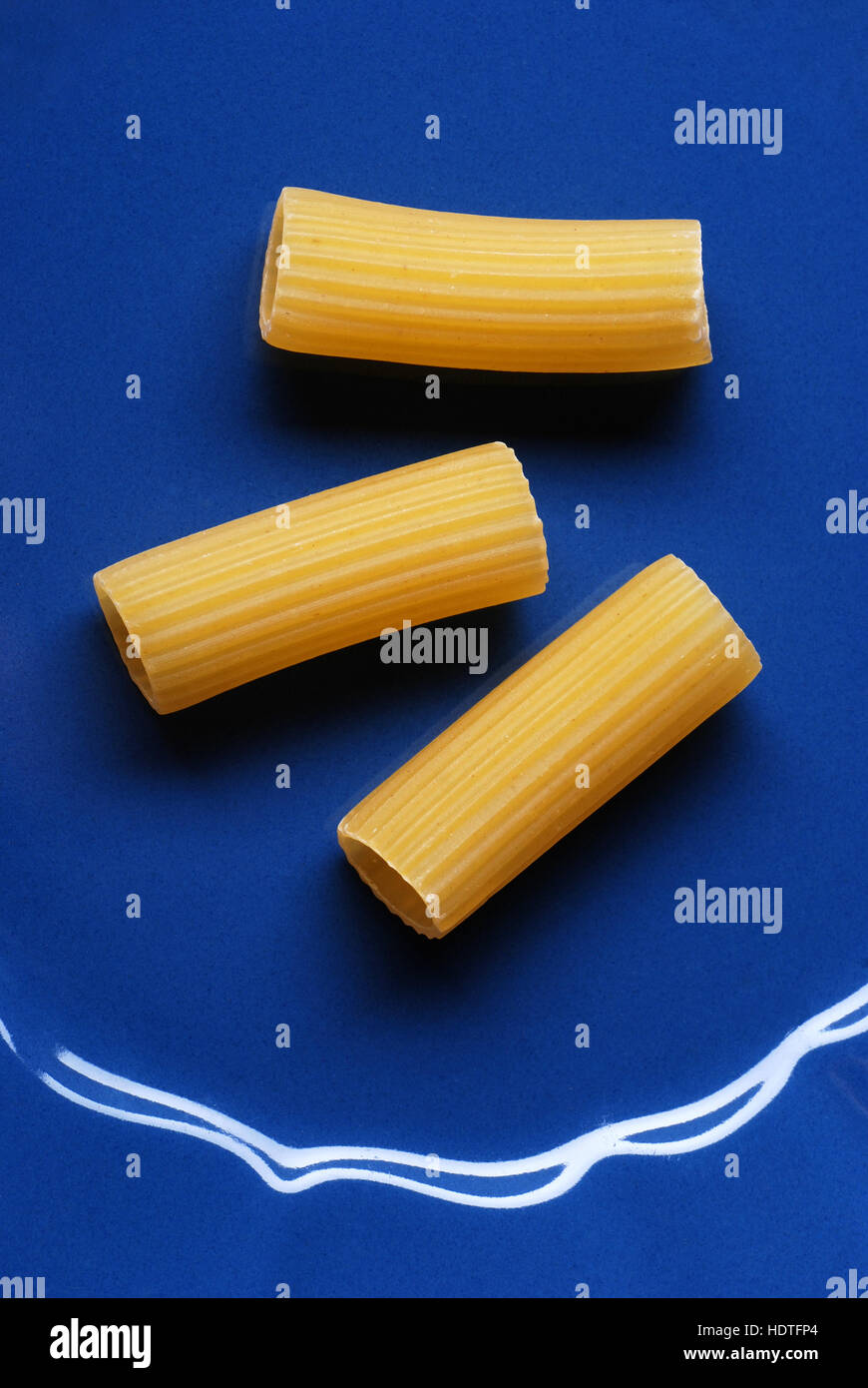 Italian raw pasta on blue dish Stock Photo - Alamy
