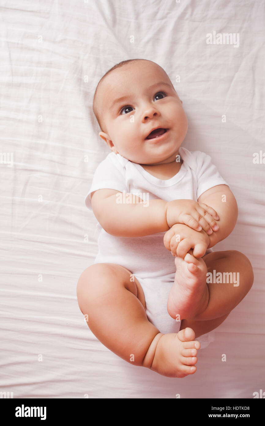 Portrait of a baby lying on the bed Stock Photo - Alamy