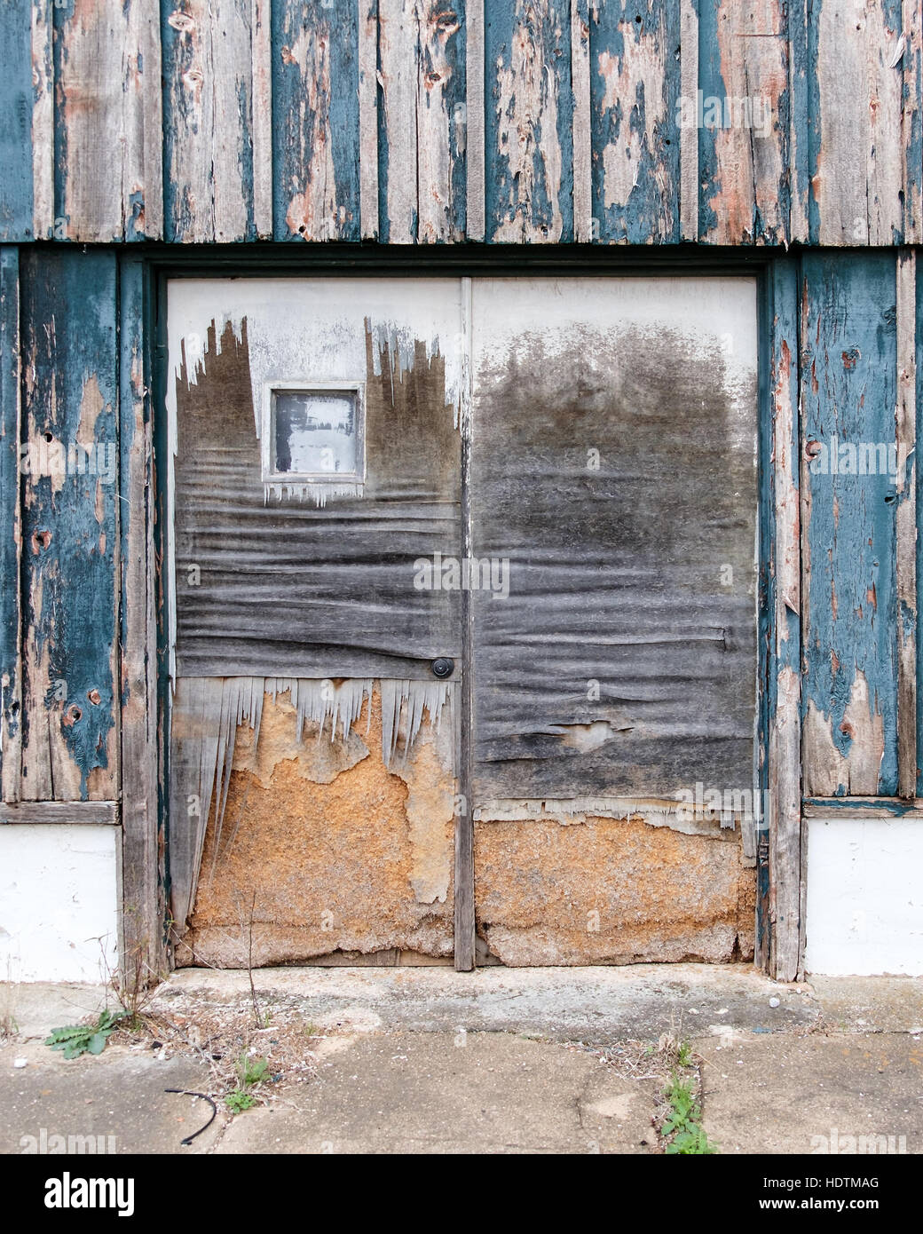 The doors of an abandoned empty deteriorating old derelict building in ...