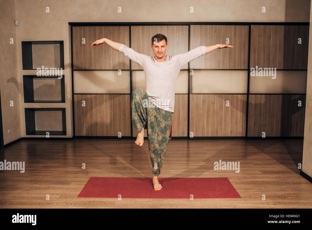 young strong man in the tree pose Stock Photo - Alamy