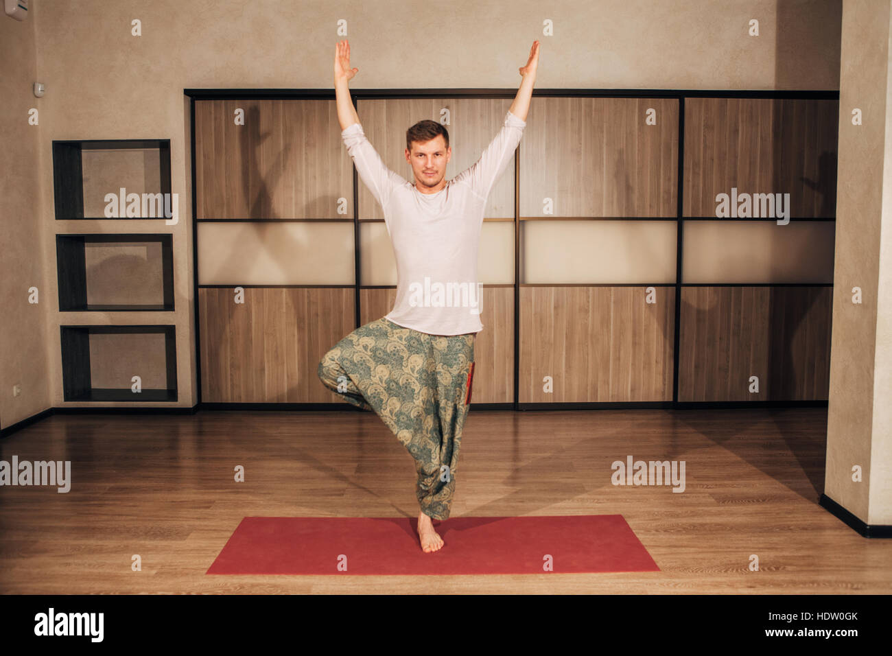 young strong man in the tree pose Stock Photo - Alamy