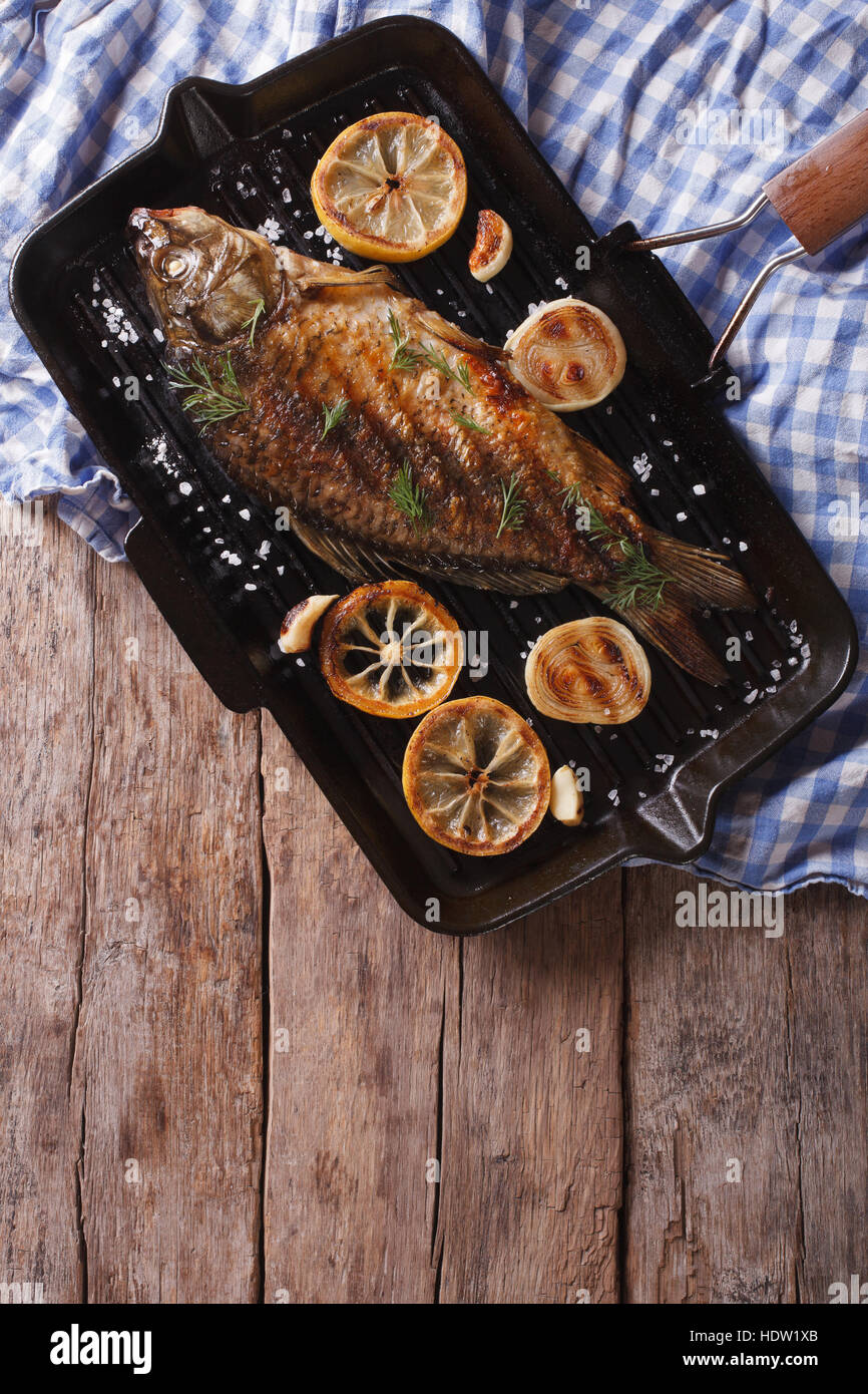 Grilled carp with lemon in a grill pan , vertical view from above ...