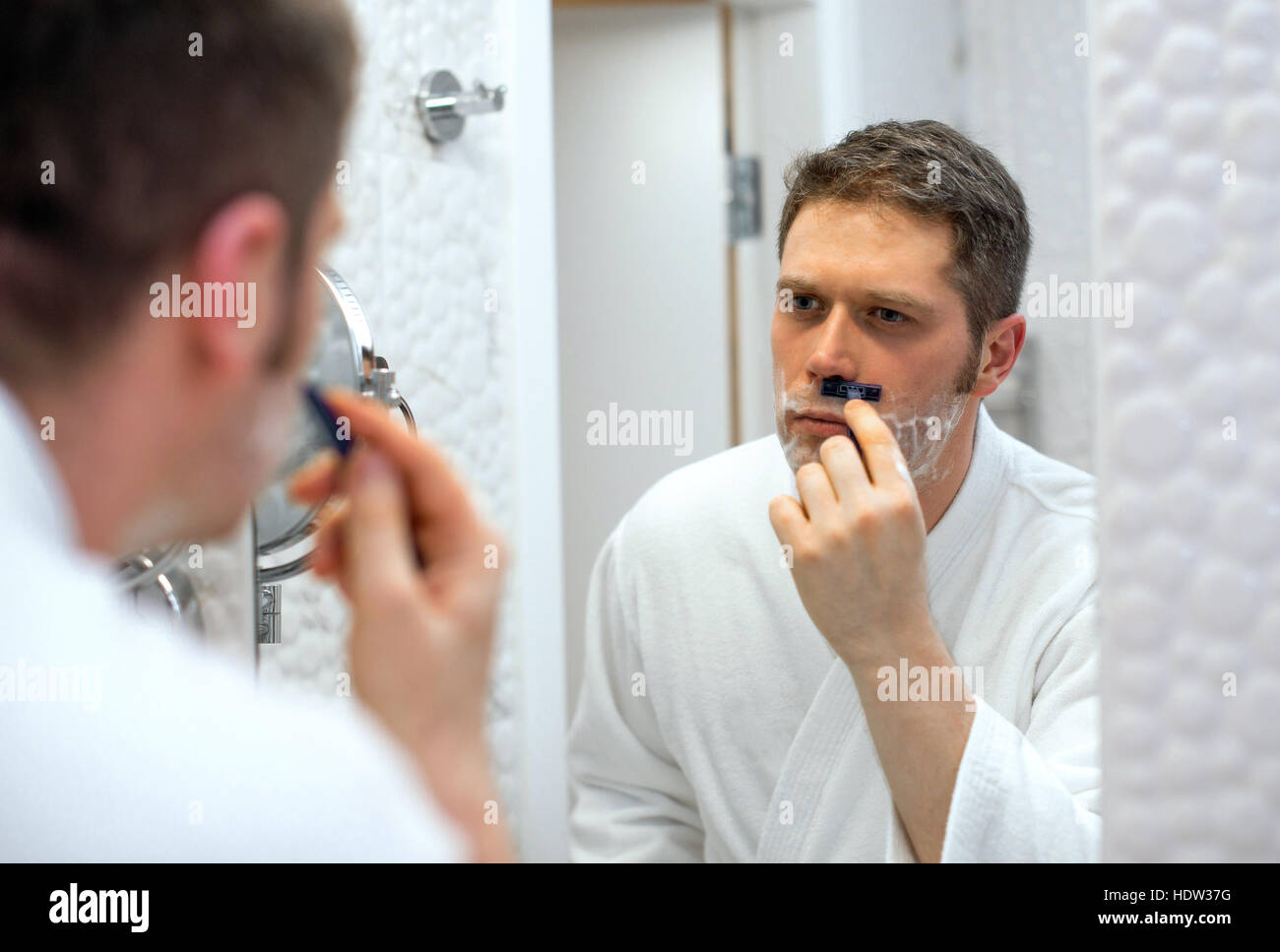 Handsome man shaving in bathroom Stock Photo - Alamy