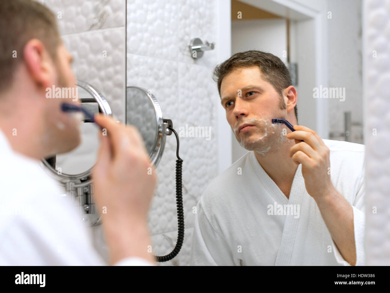 Handsome man shaving in bathroom Stock Photo - Alamy