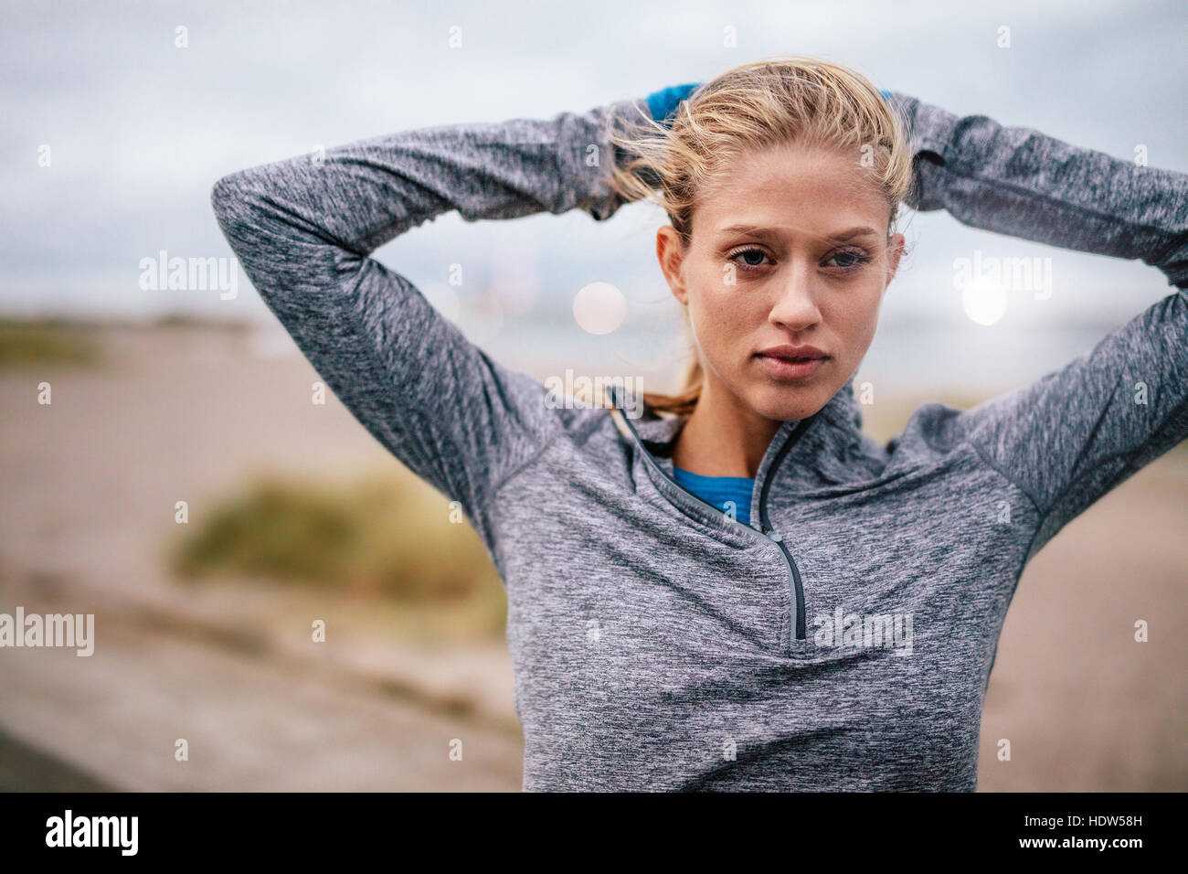 fitness woman tying hair before her workout. Young woman getting ready ...