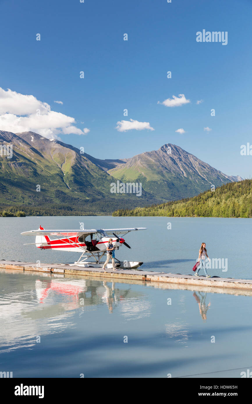 Two Women Disembark From A Float Plane Docked At The Trail Lake Float ...