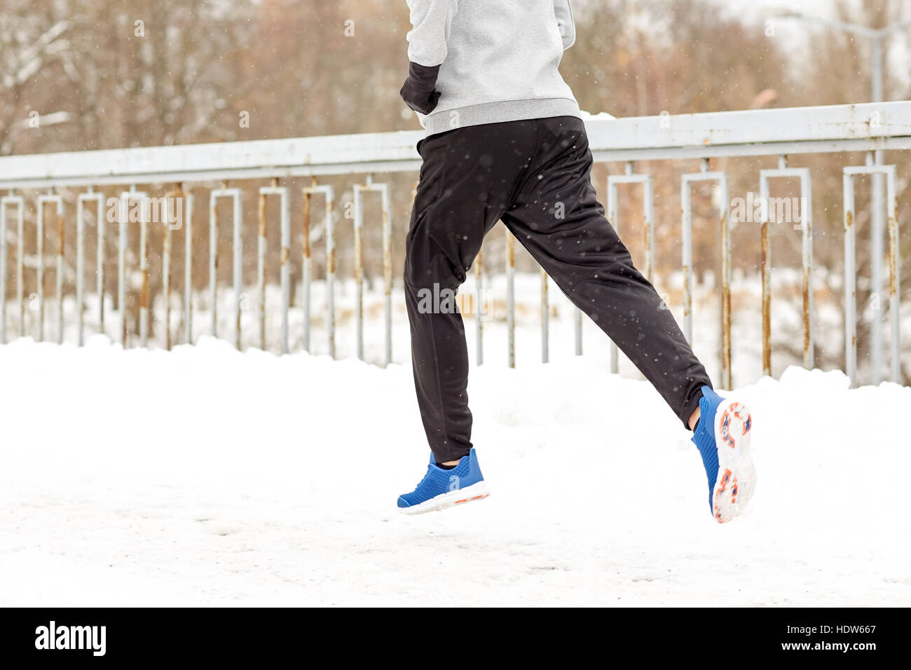 man running along snow covered winter bridge road Stock Photo - Alamy