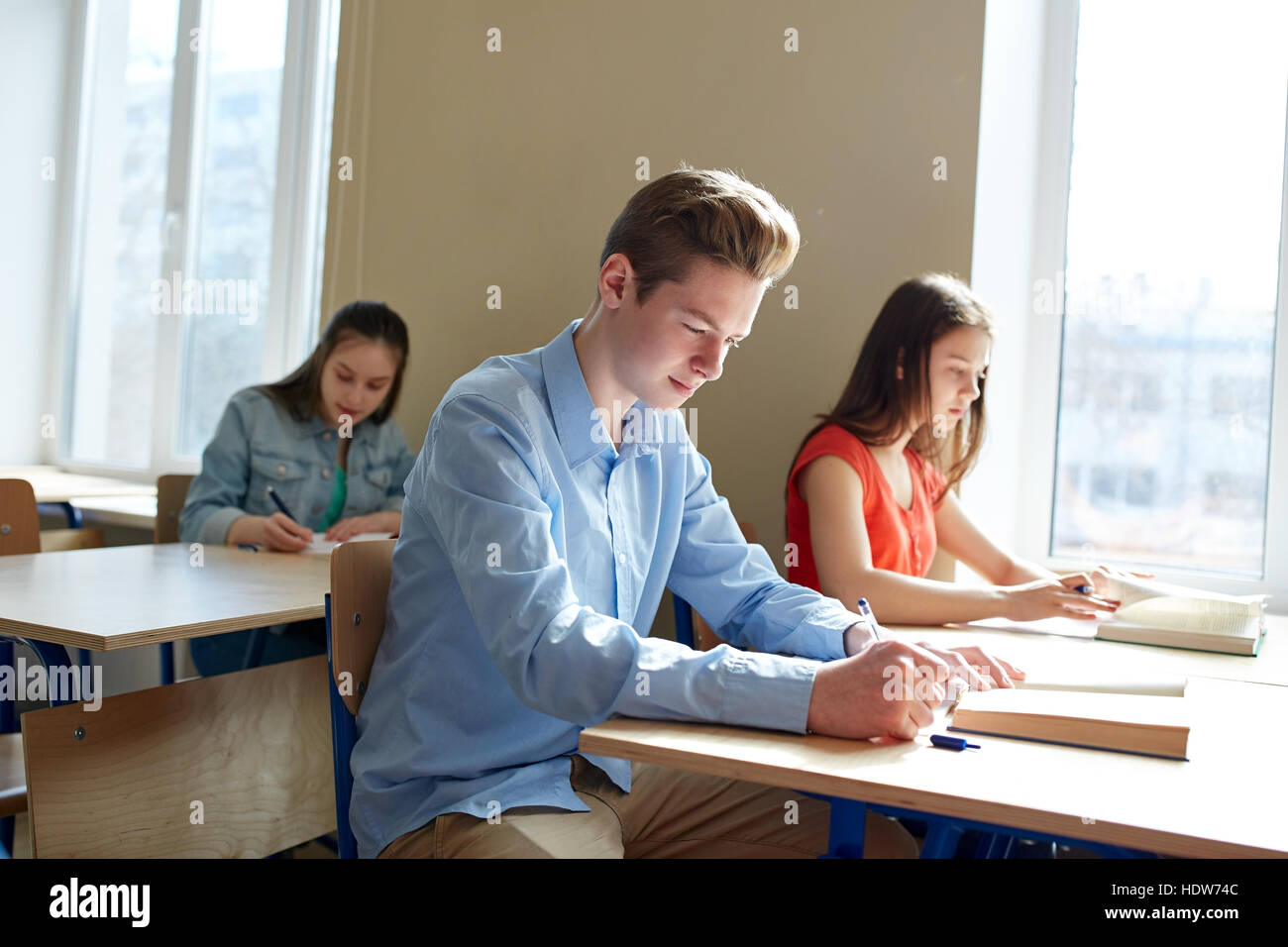 group of students with books writing school test Stock Photo - Alamy