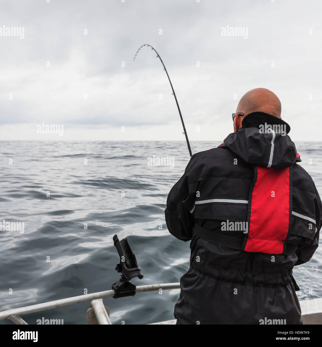 A man fishing from a fishing boat off the Queen Charlotte Islands ...