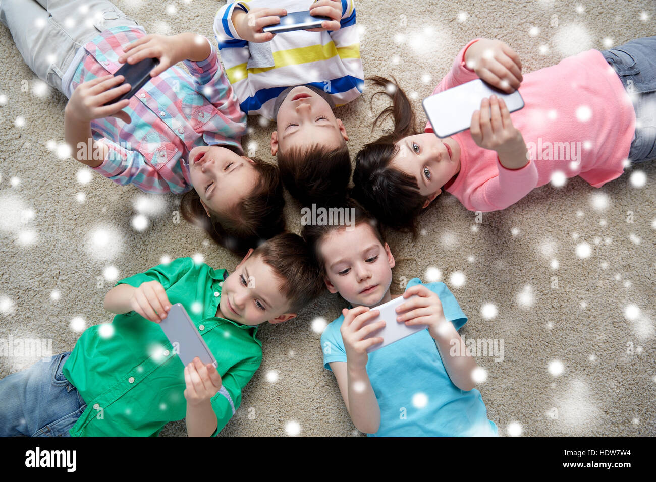 children with smartphones lying on floor Stock Photo - Alamy