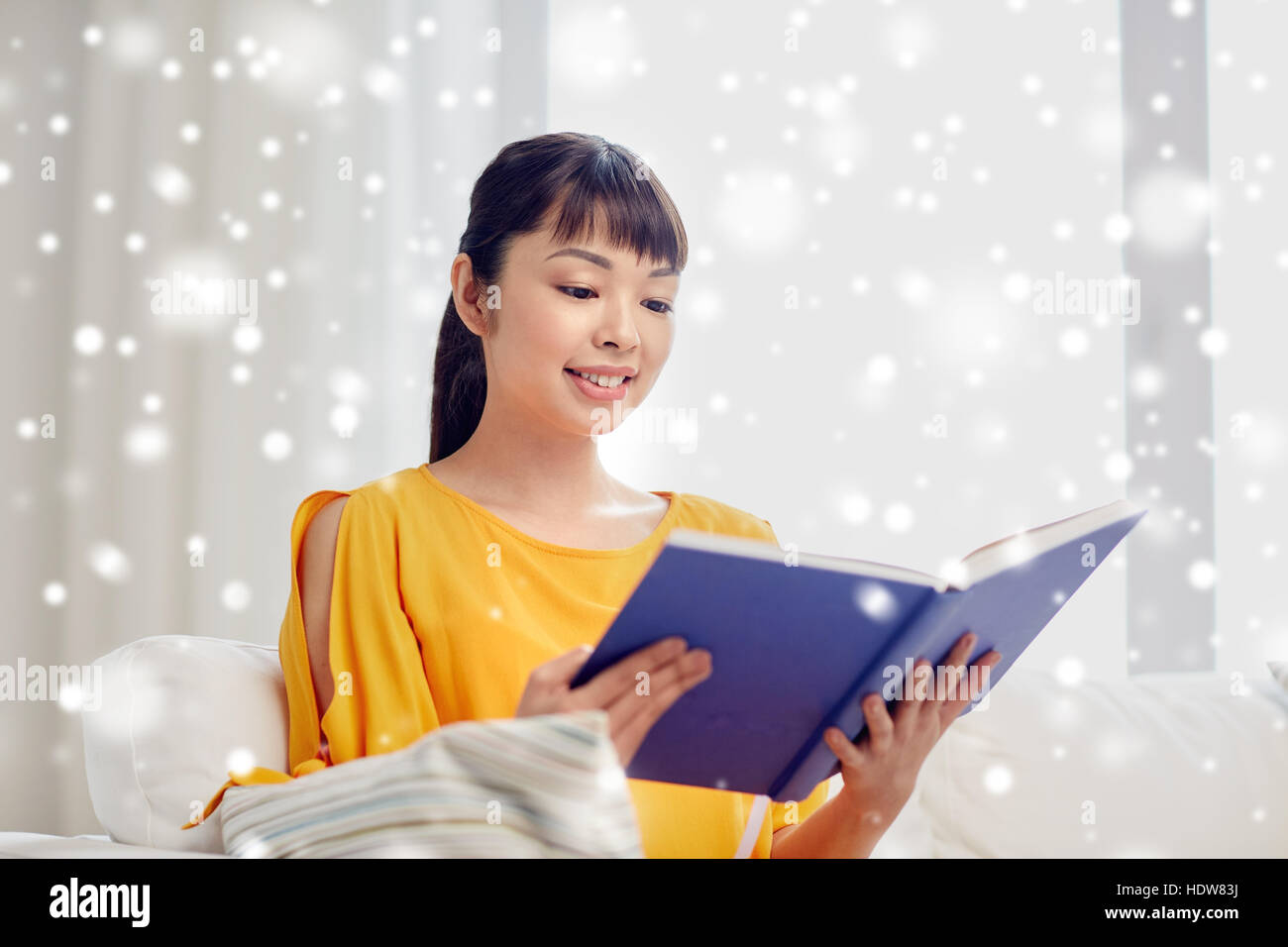 smiling young asian woman reading book at home Stock Photo - Alamy