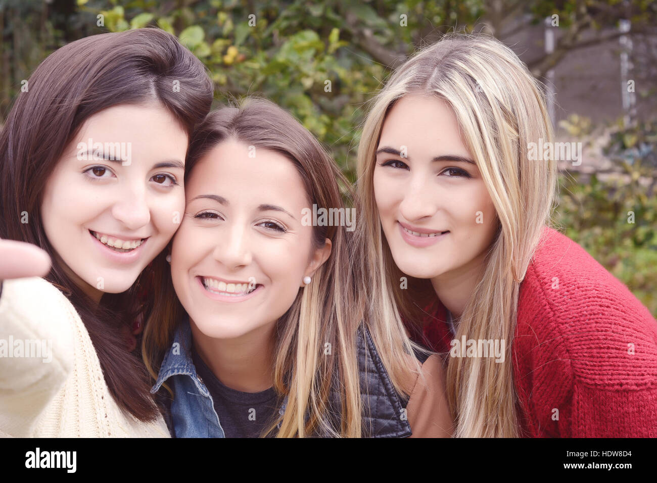 Portrait of three and beautiful young friends having fun and taking ...