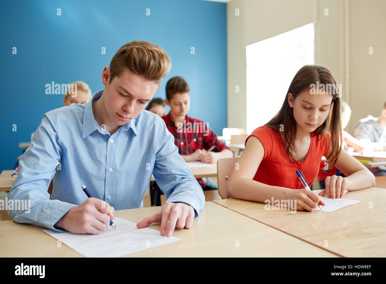 group of students with books writing school test Stock Photo - Alamy