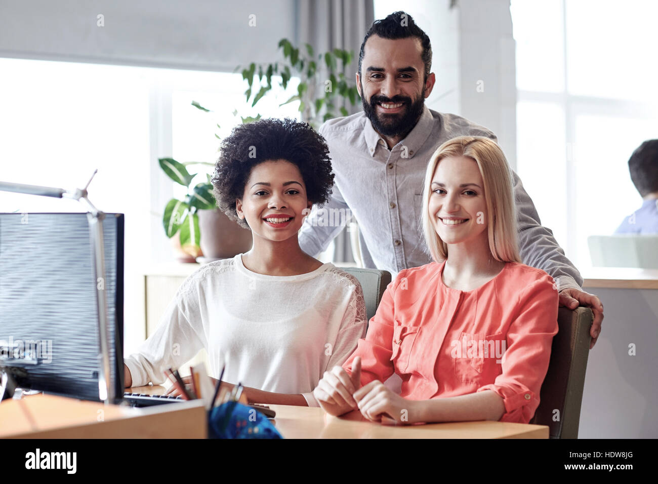 happy creative team with computer in office Stock Photo - Alamy