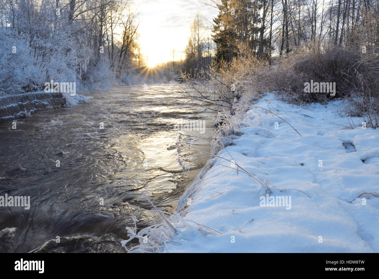 Little stream in the light of the midwinter sun just over horizon in ...