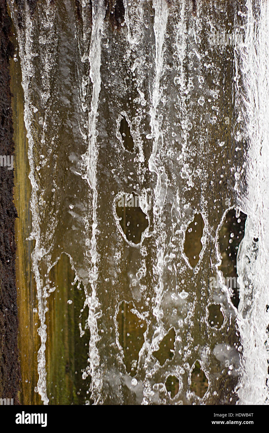 Water falling from a storm drain captured frozen in time producing ...